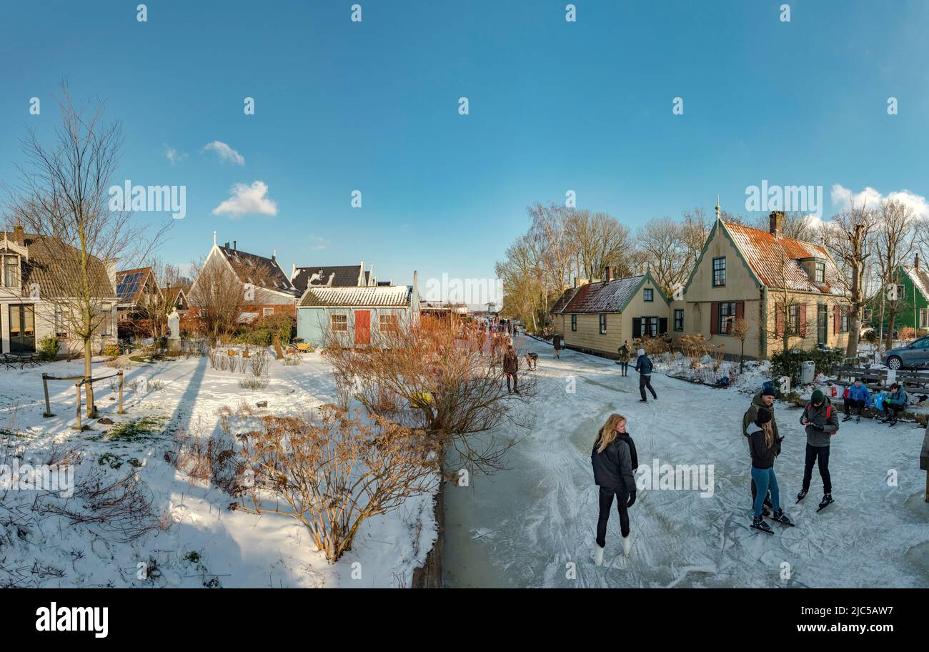 Scating at a frozen canal near wooden houses *** Local Caption ...