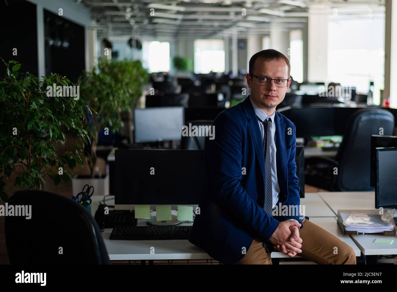 Happy male employee at the workplace in the office Open Space. Friendly ...
