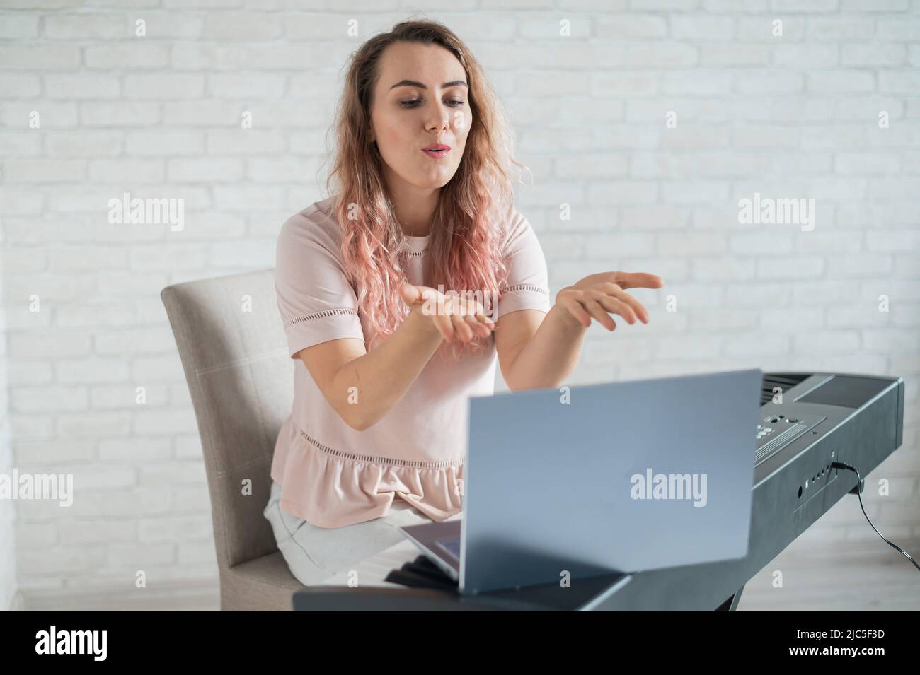 A friendly woman plays the electronic piano and conducts a video blog ...