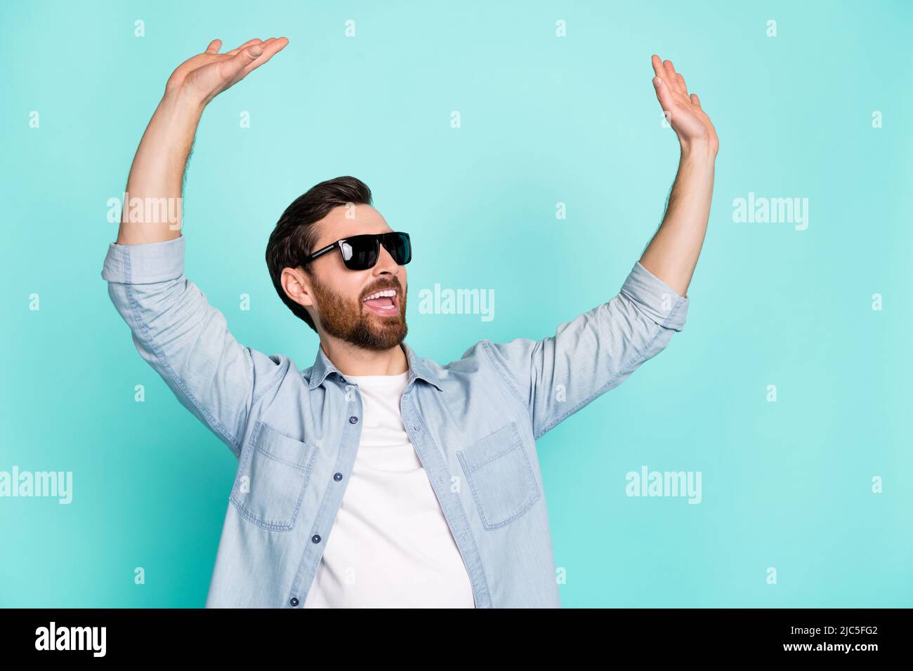 Photo of satisfied cheerful person raise hands dancing enjoy free time ...