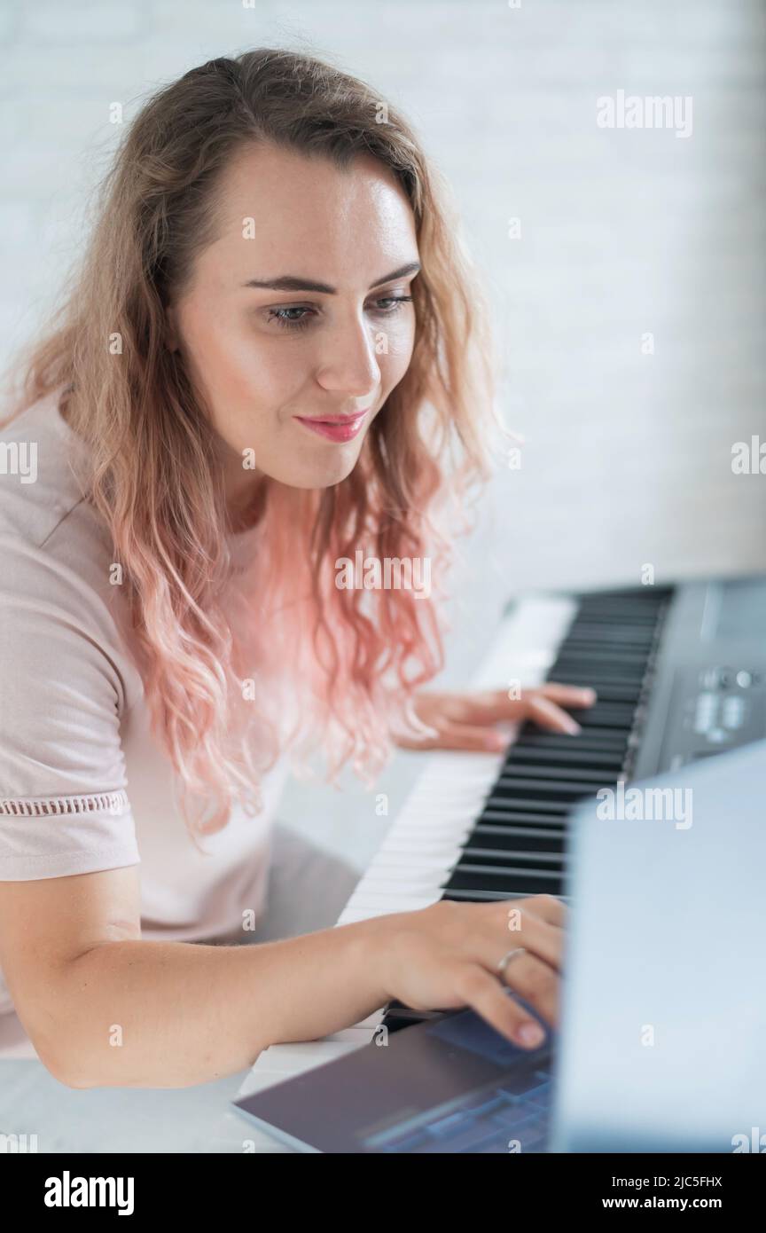 A friendly woman plays the electronic piano and conducts a video blog ...