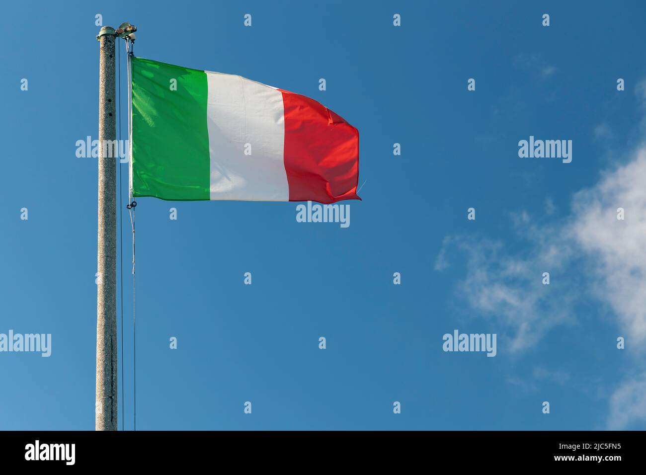 Italian flag blowing in the wind in the blue sky Stock Photo - Alamy