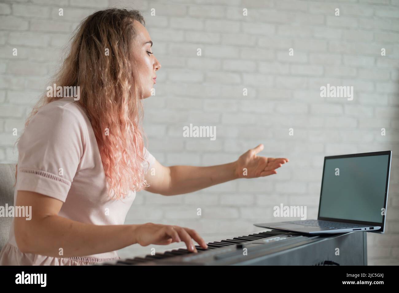 A friendly woman plays the electronic piano and conducts a video blog ...