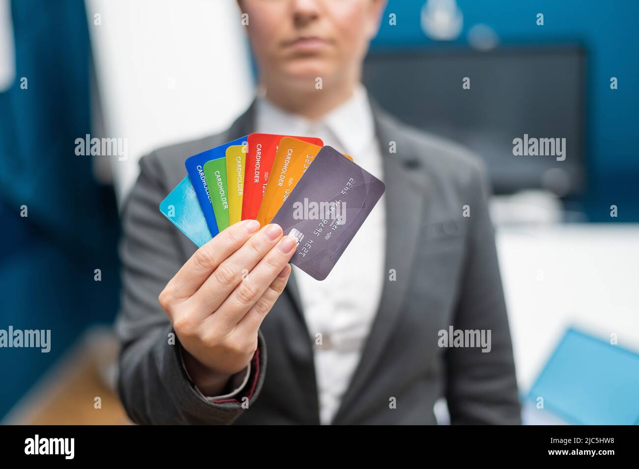 Unrecognizable woman dressed in a suit holds multi-colored plastic ...