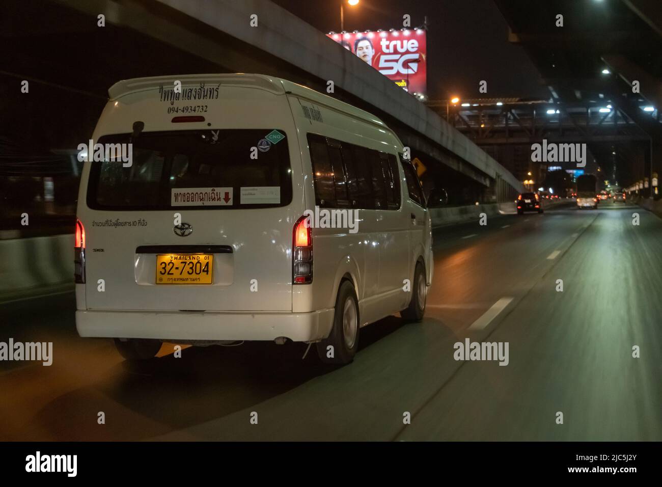 BANGKOK, THAILAND, APR 06 2022, A minivan is driving through the night ...