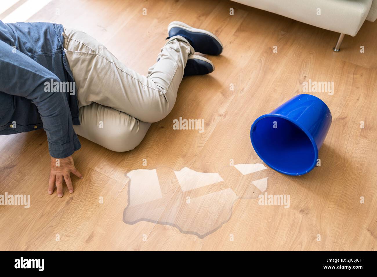 Mature Man Falling On Wet Floor In Front Spilled Bucket Of Water At ...