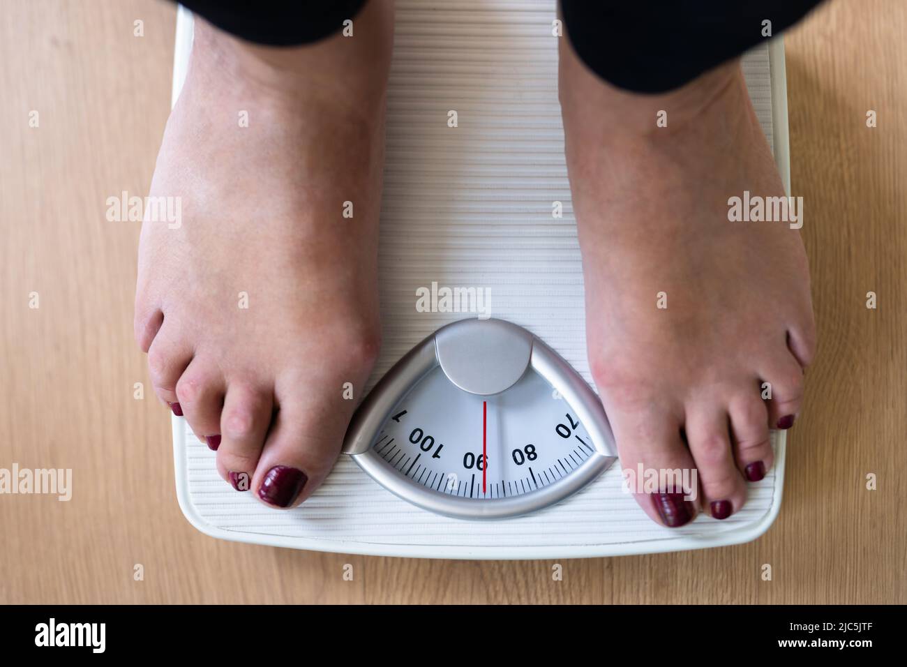 Low Section Of A Person Standing On Weighing Scale Stock Photo - Alamy