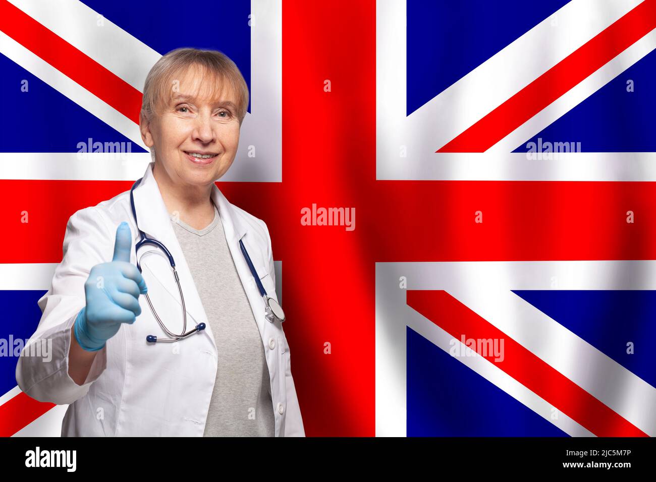 UK smiling mature doctor with stethoscope on flag of United Kingdom ...
