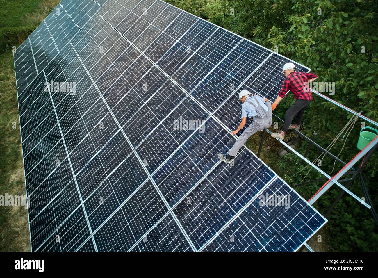 Aerial view of men technicians installing solar panels to high steel ...