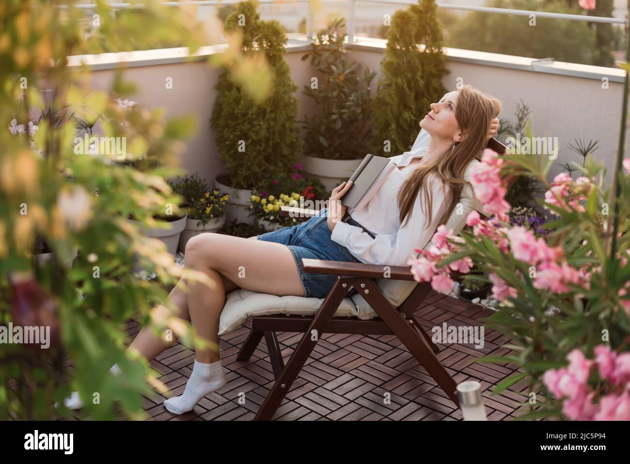 Dreamy Woman Holding a Book to Chest Stock Photo - Alamy