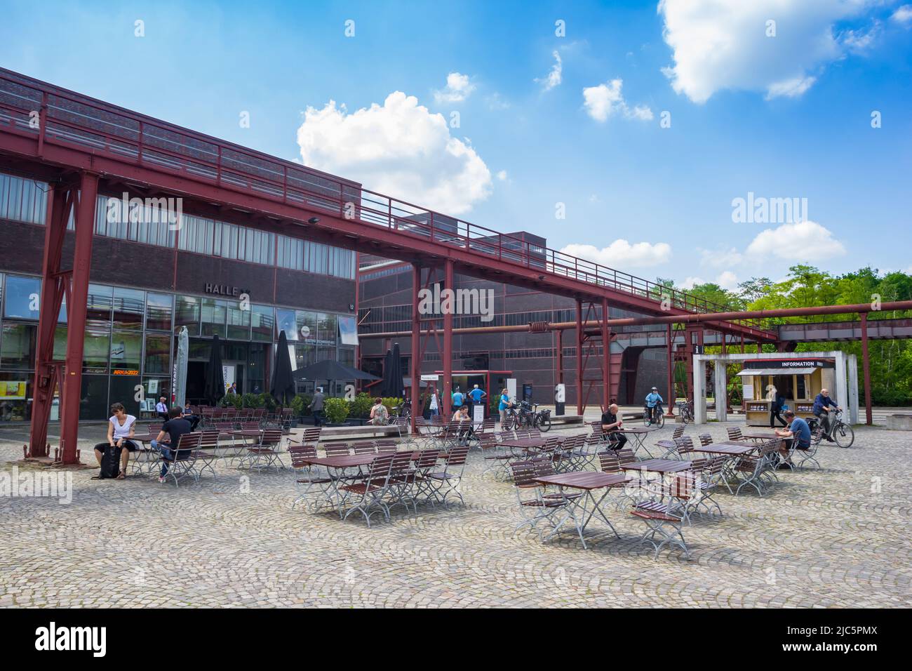 People sitting at the tables of the cafe in Zollverein in Essen ...