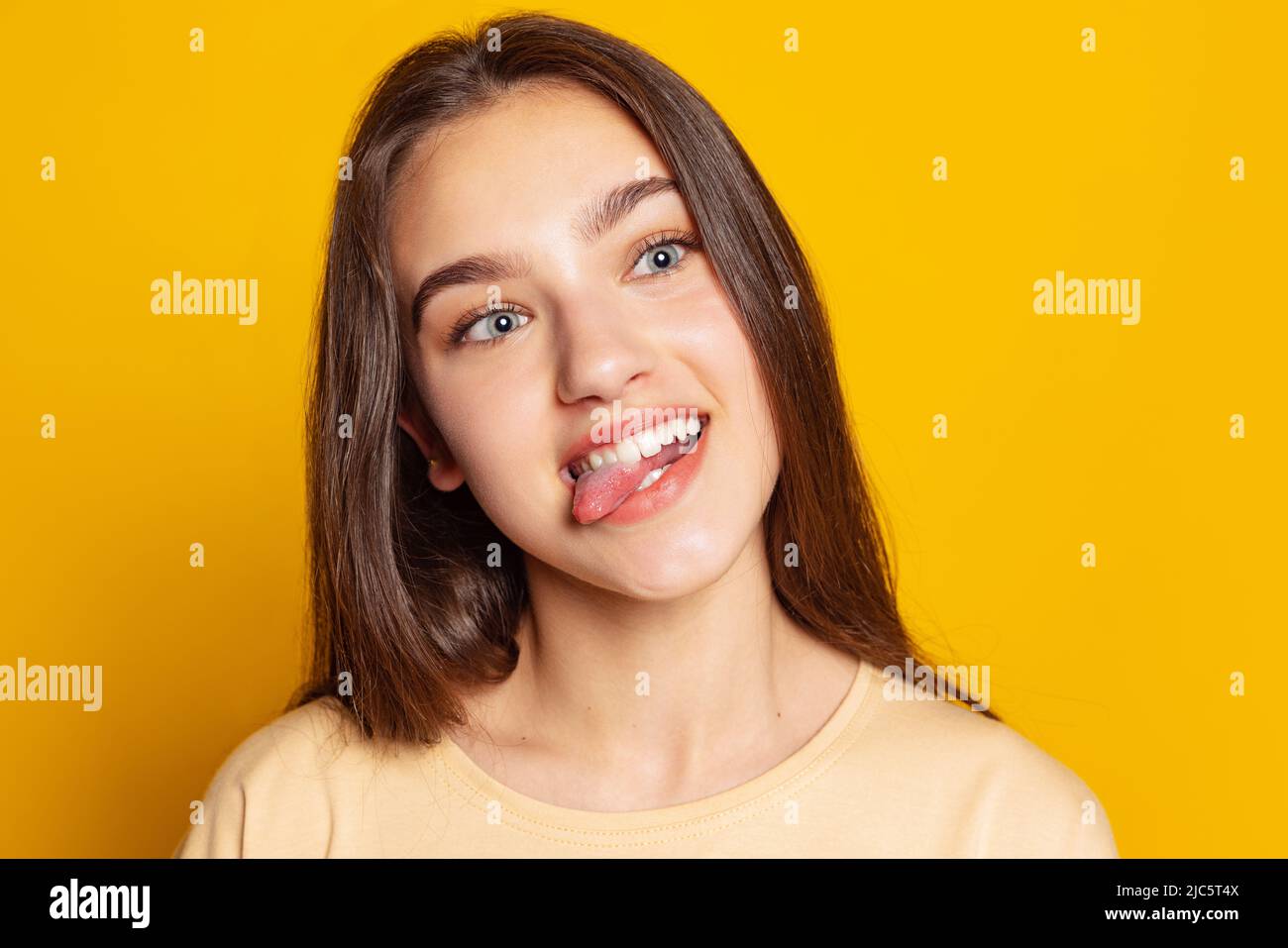 Funny girl making face, grimaces isolated on yellow background. Concept ...