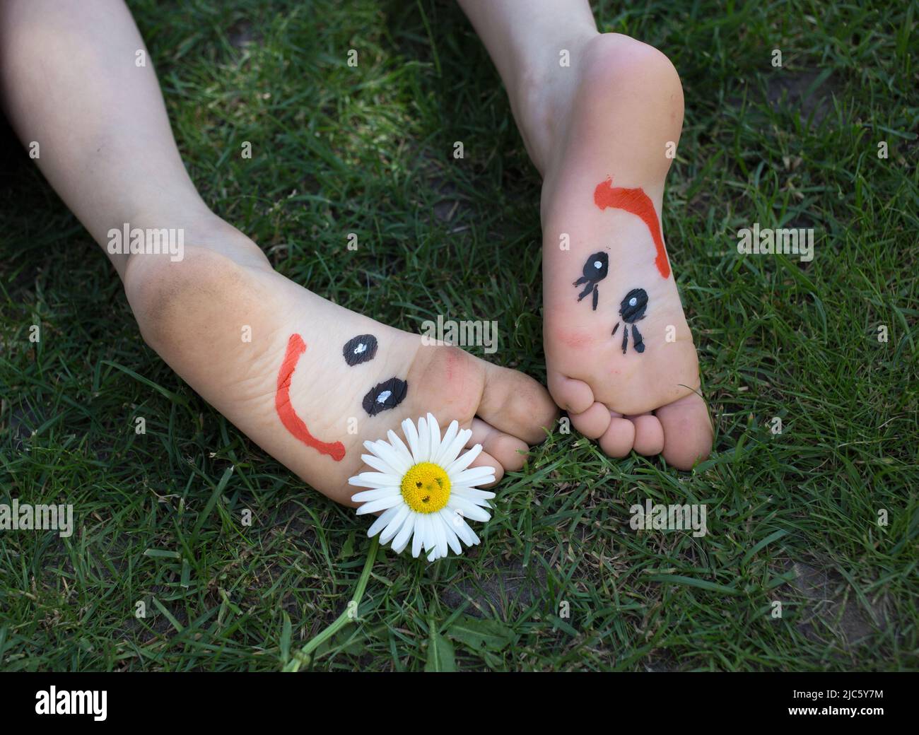 satisfied smiles are drawn on the two left children's bare feet, the ...