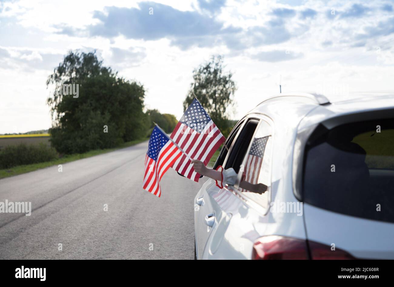 two American flags hanging out of the car window. USA Independence Day ...