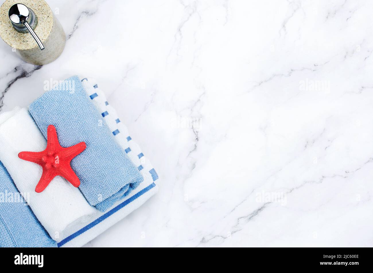 Towels stack and soap dispenser on bathroom table top view empty space ...