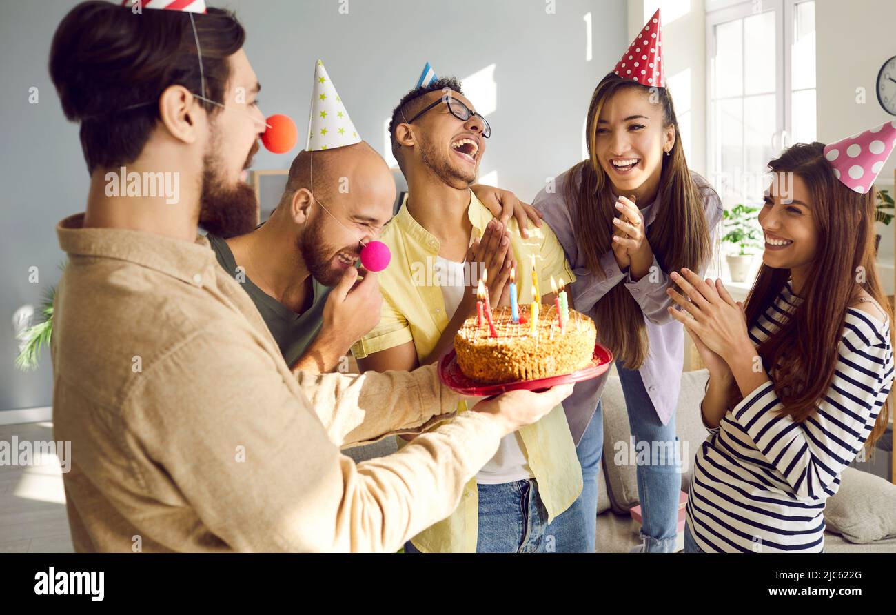 Happy friends greeting girl colleague with birthday Stock Photo - Alamy