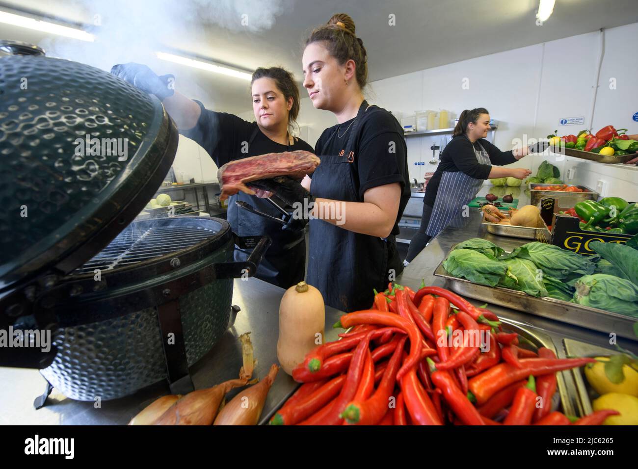 Chefs placing some pork in a wood smoker Stock Photo - Alamy