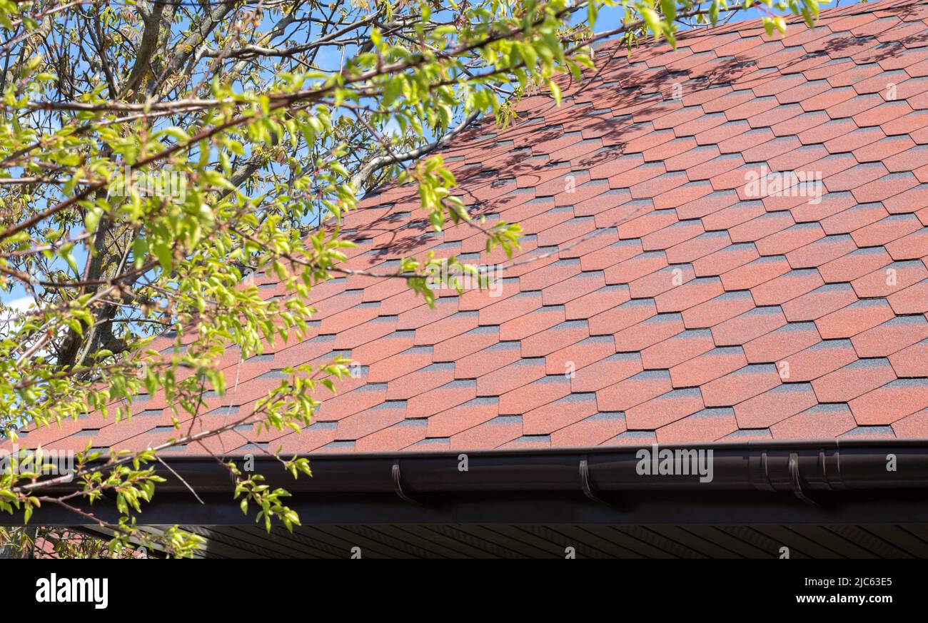 New roof with red shingles against the blue sky. High quality photo ...