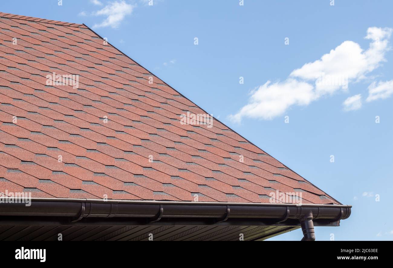 New roof with red shingles against the blue sky. High quality photo ...