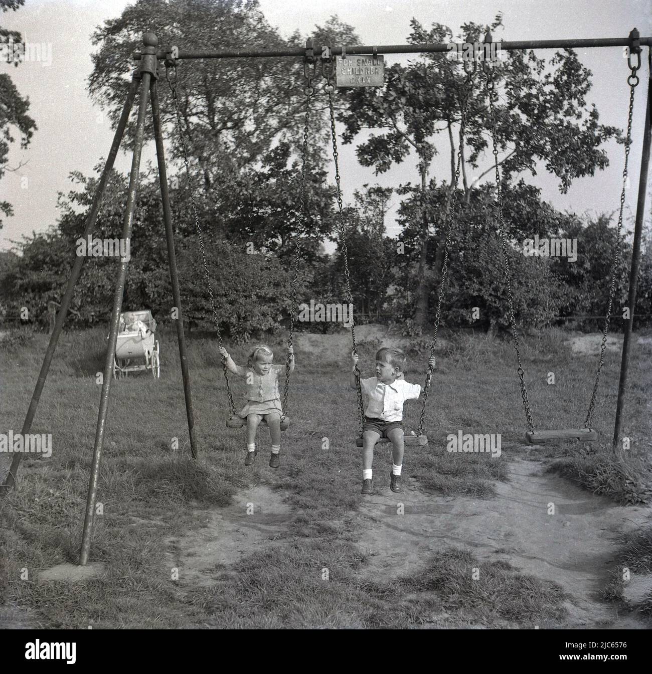 1950s, historical, outside in a countryside playground, a small boy and ...