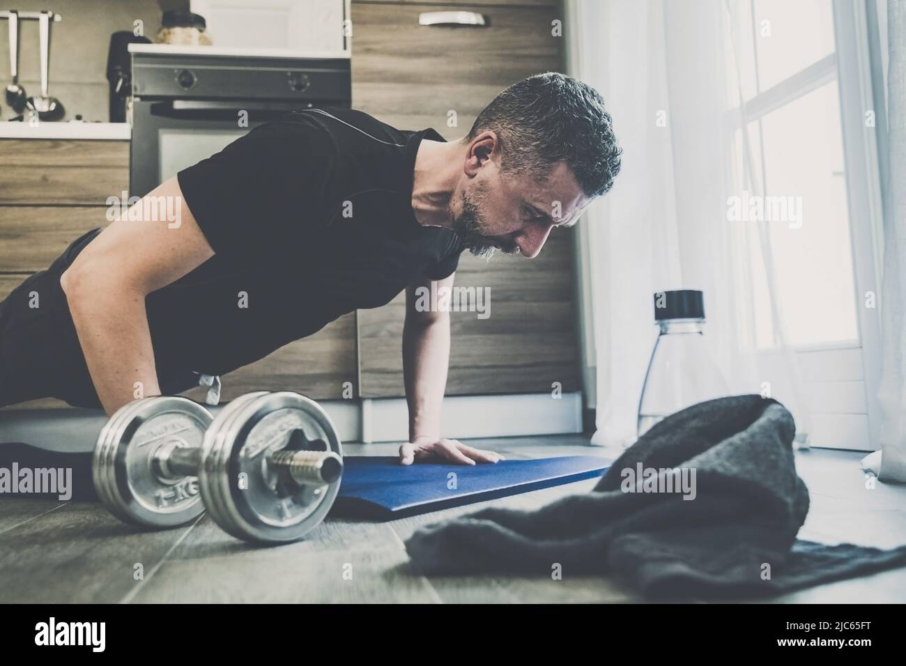 Determined sporty young man working out and trains at home. Fit boy ...
