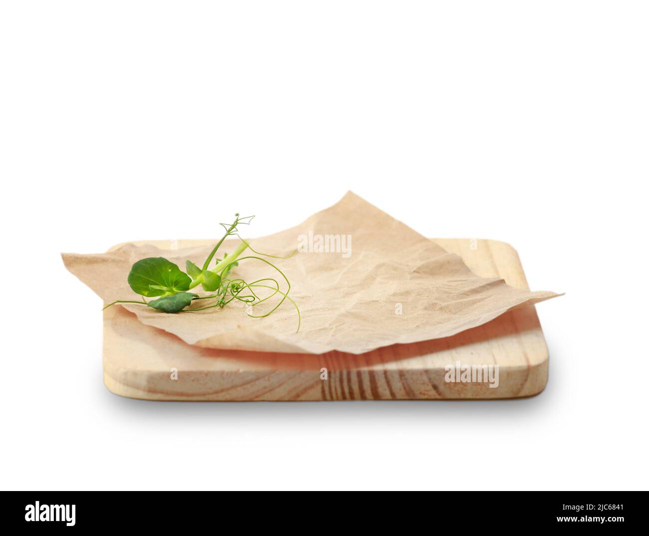 Wooden dish board and crumpled paper decorated with green leaves ...