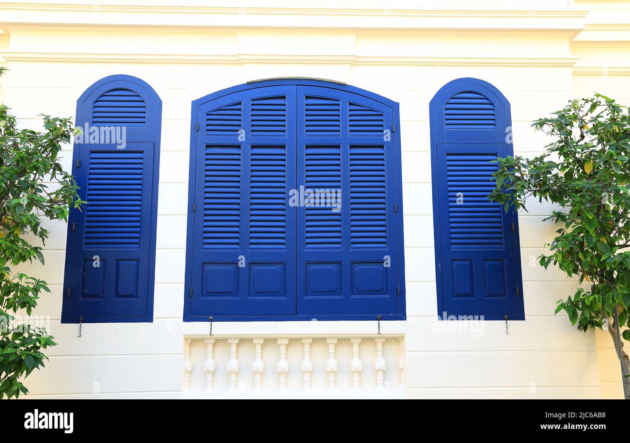 dusty white ancient building facade with beautiful blue wooden windows ...