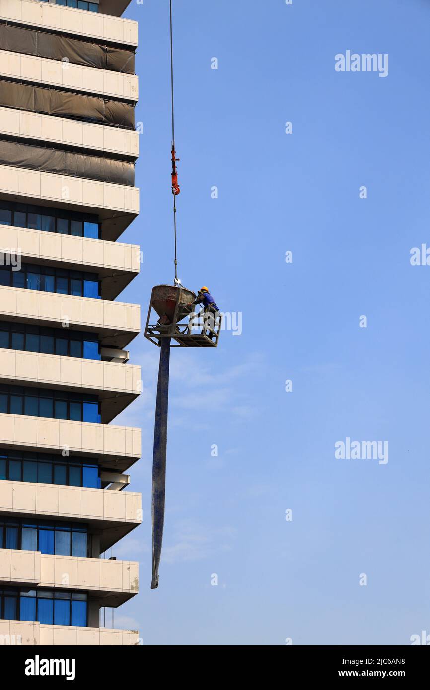 Workers concreting the skyscraper by crane on high rise, builder worker ...