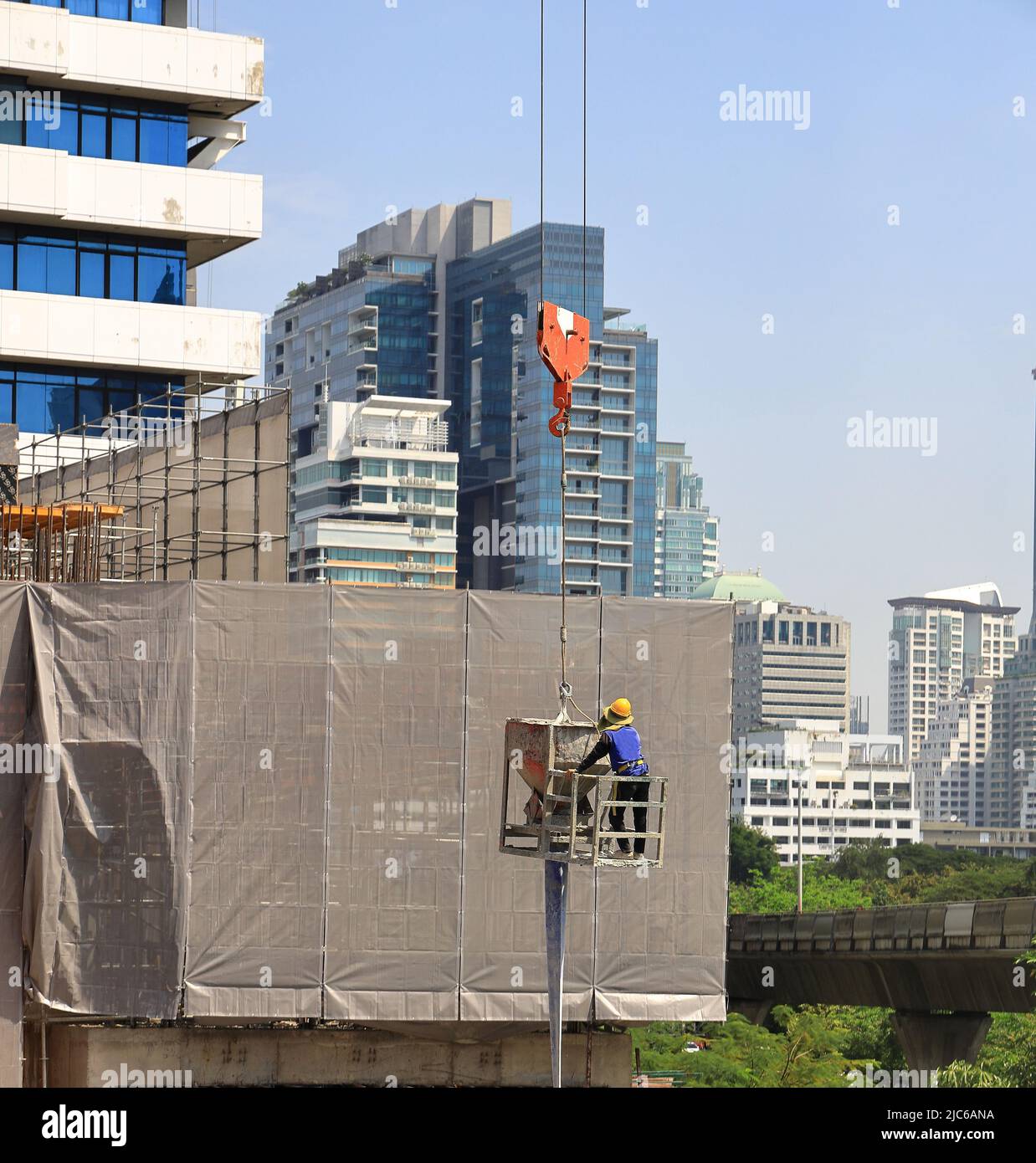 Workers concreting the skyscraper by crane on high rise, builder worker ...