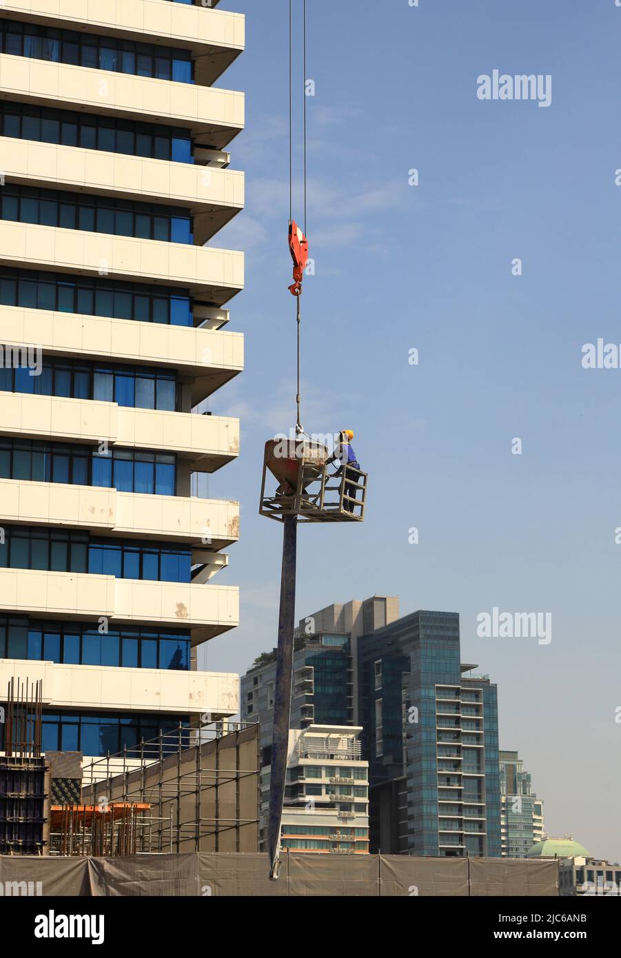 Workers concreting the skyscraper by crane on high rise, builder worker ...
