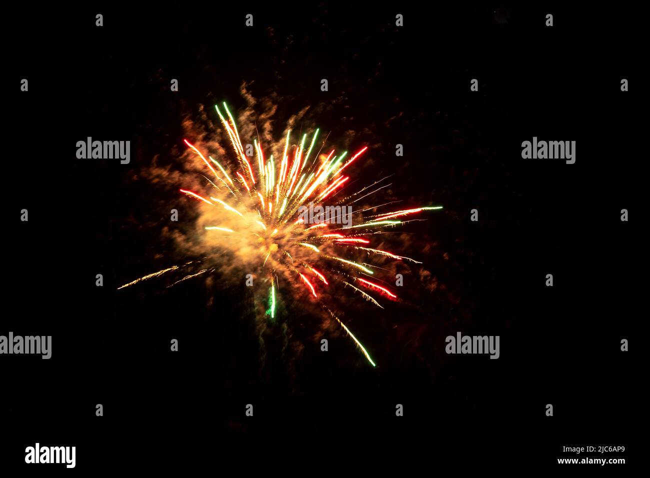 A portrait of fireworks exploding giving us a view on green, red and ...