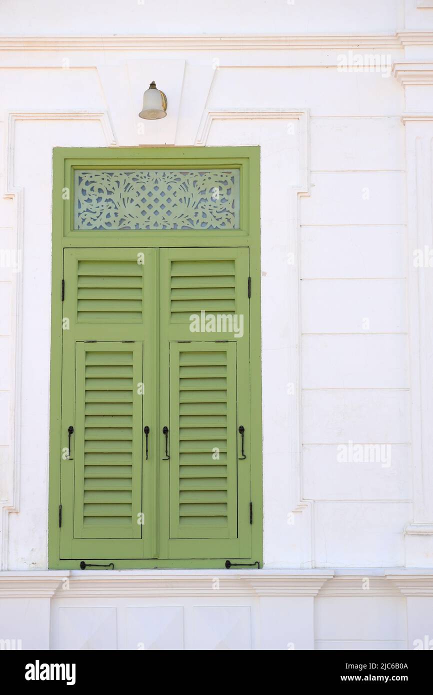 dusty white ancient building facade with beautiful green wooden windows ...