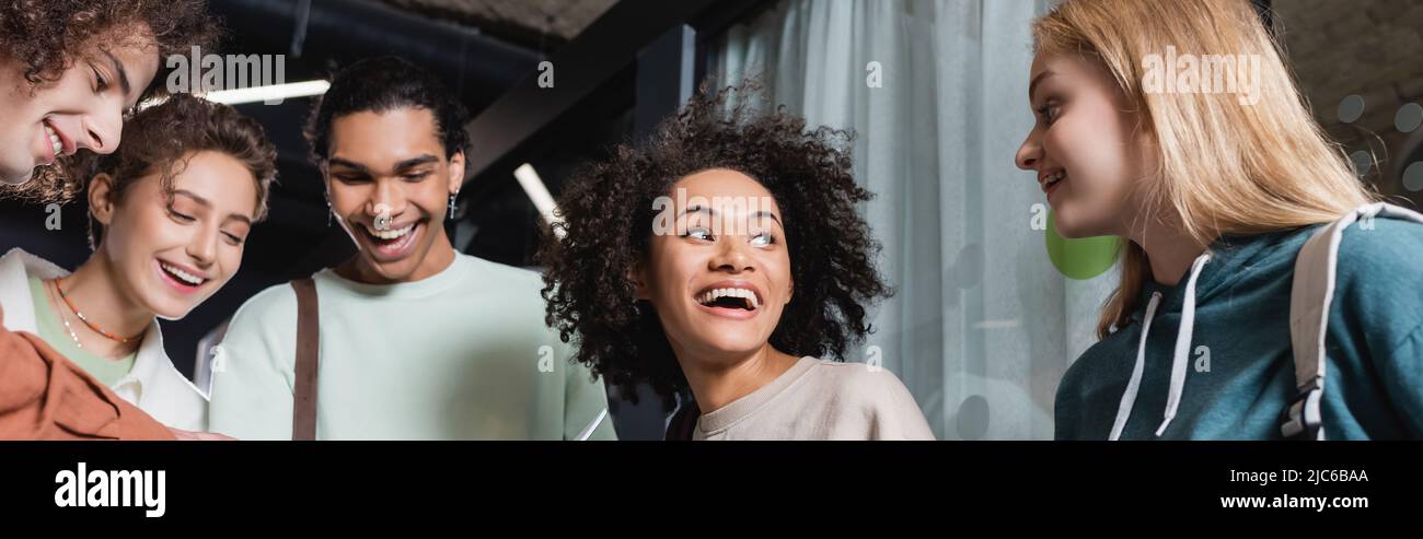 african american woman laughing near smiling interracial students ...