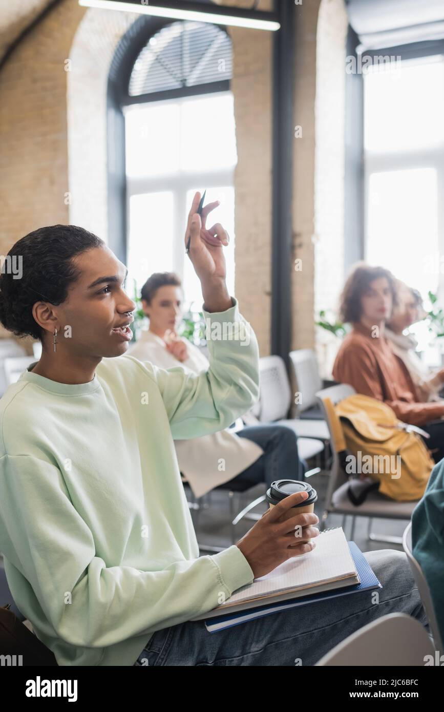african american student with coffee to go and raised hand asking ...