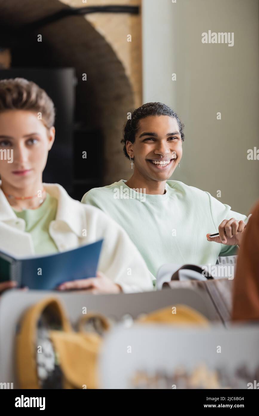 young african american man smiling during lecture in university near ...