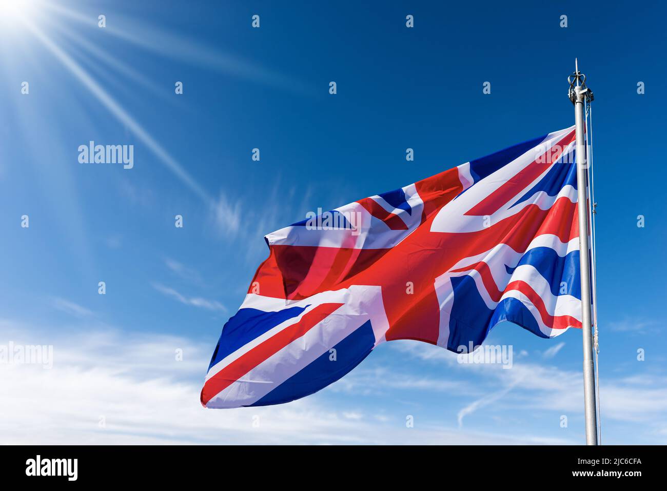 Close-up of a national UK flag with flagpole, blowing in the wind on a ...