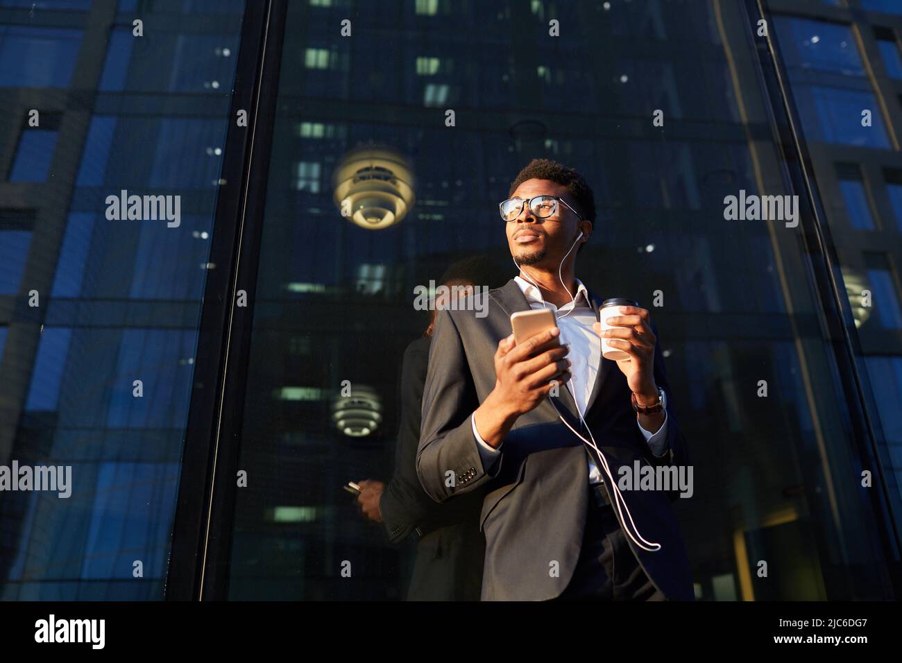 Low angle view of serious thoughtful young African-American businessman ...