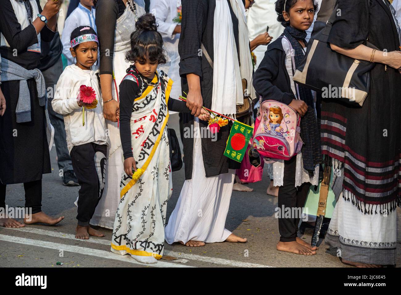 A crowd marches through the street to commemorate the sacrifices of the ...