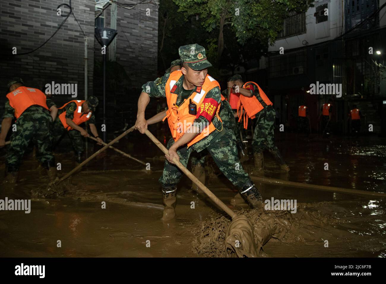 LIIUZHOU, CHINA - JUNE 6, 2022 - Armed police officers clear mud in ...
