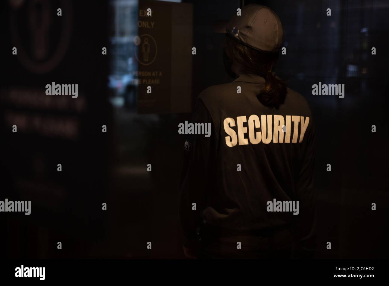Female security guard walking through an automated revolving curved ...