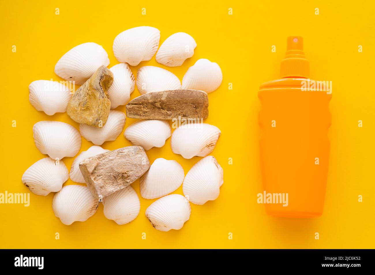 Top view of sunblock near white seashells on yellow background Stock ...