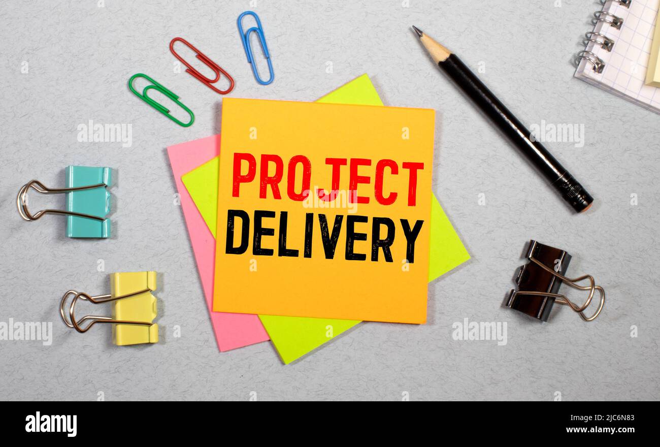 businesman hold notepad with text PROJECT DELIVERY. White background ...