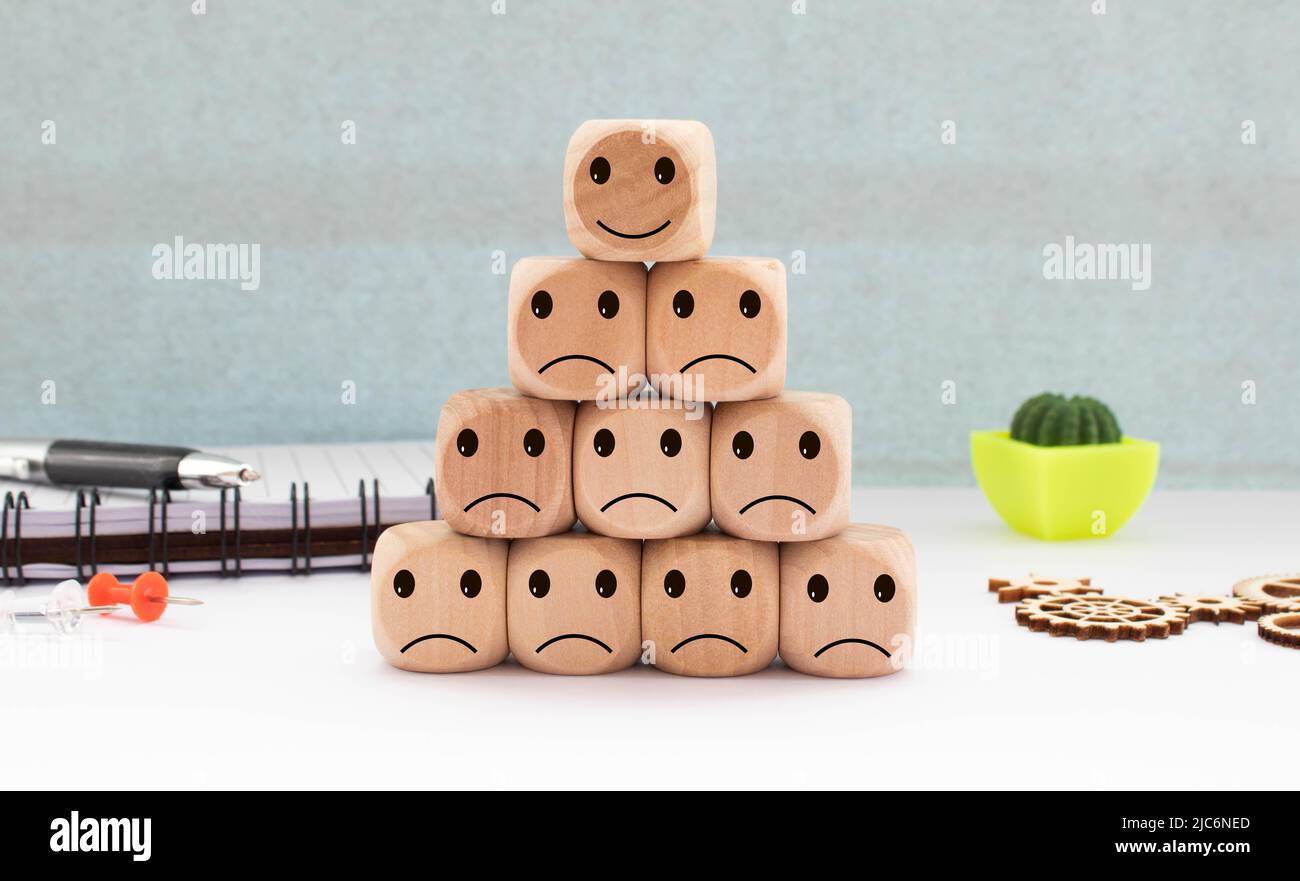 Wooden blocks with a smile of a happy and not happy face on the table ...