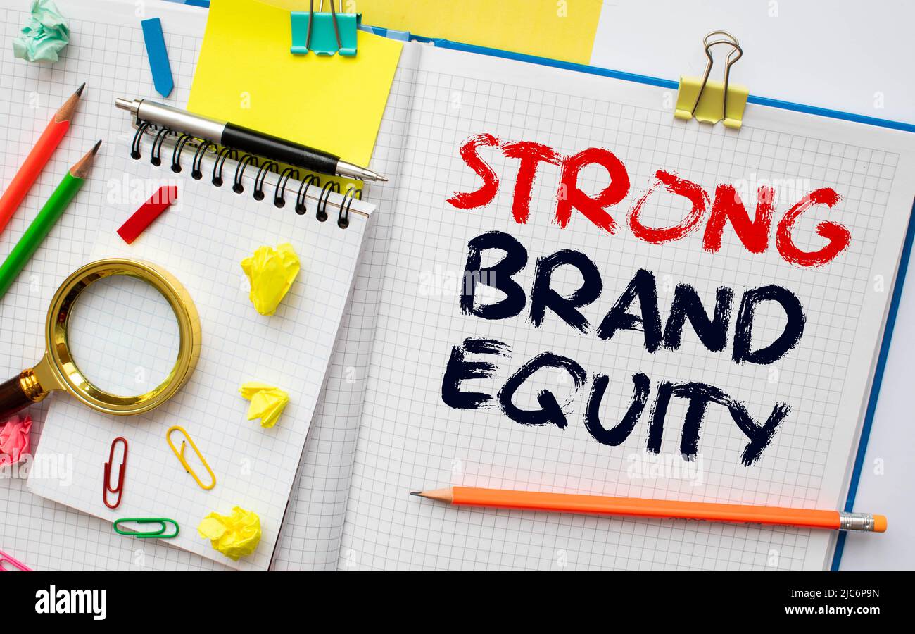 Laptop, red pen and notepad with text STRONG BRAND EQUITY in the white ...