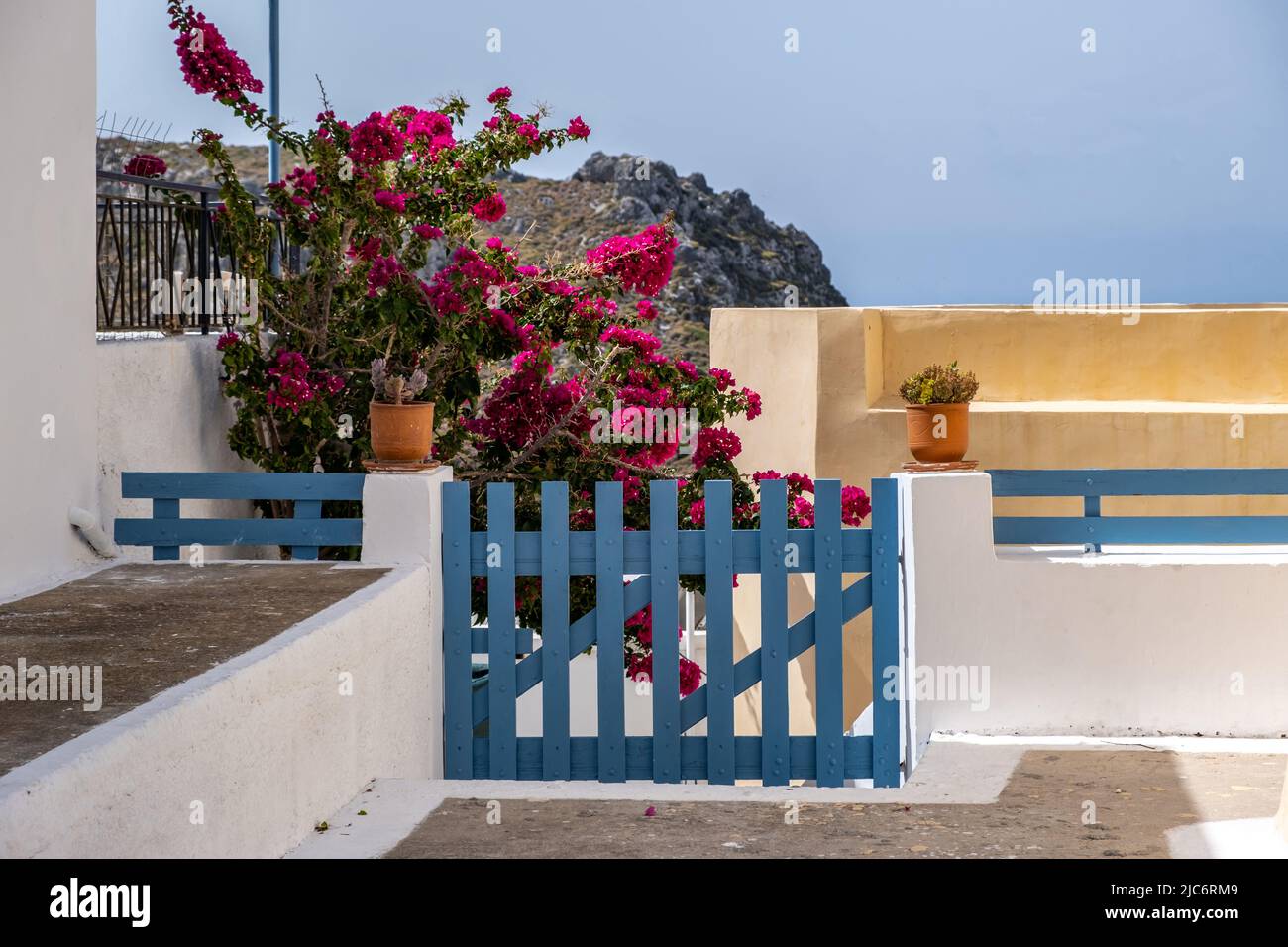 Greek Island, Cyclades. Blue wood fence entrance gate closed, red ...
