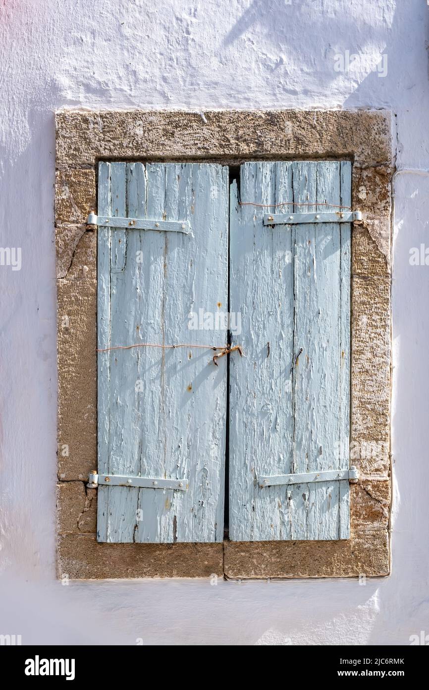 Window with closed wooden shutters on white wall background. Cyclades ...