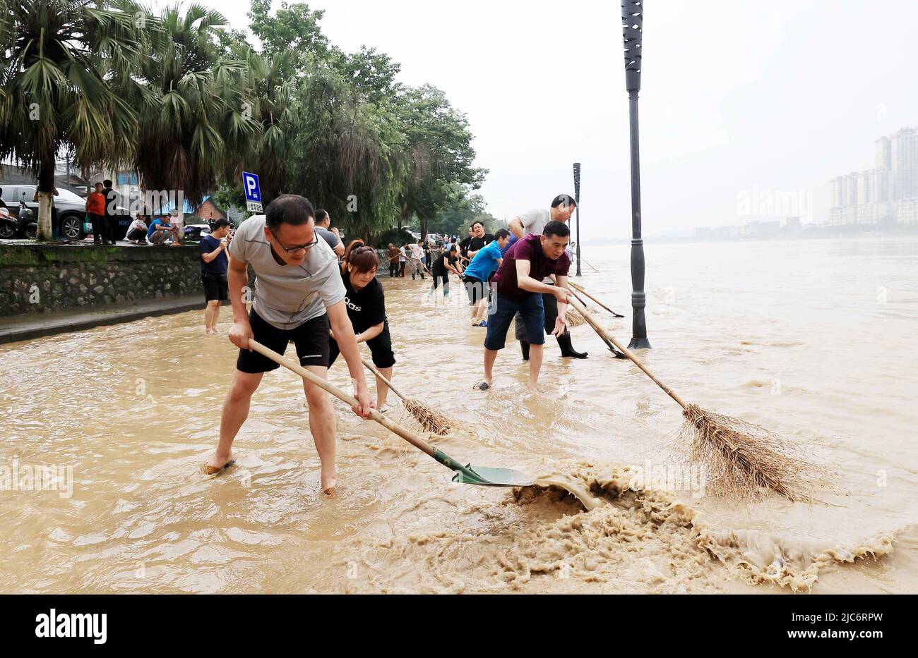 LIUZHOU, CHINA - JUNE 5, 2022 - People clean silt from a riverbank in ...
