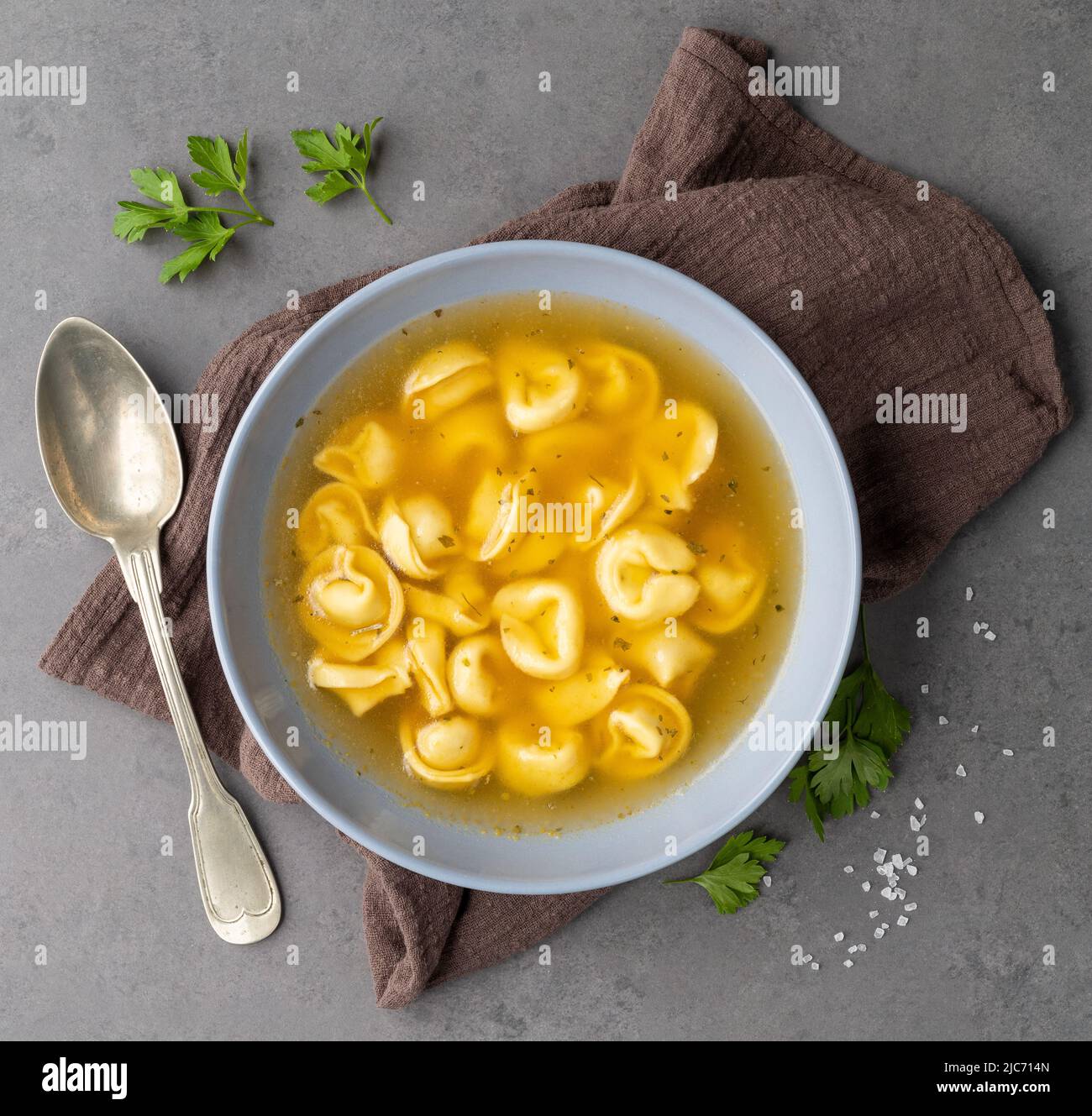 Cappelletti or tortellini brodo soup in a bowl with seasoning over ...