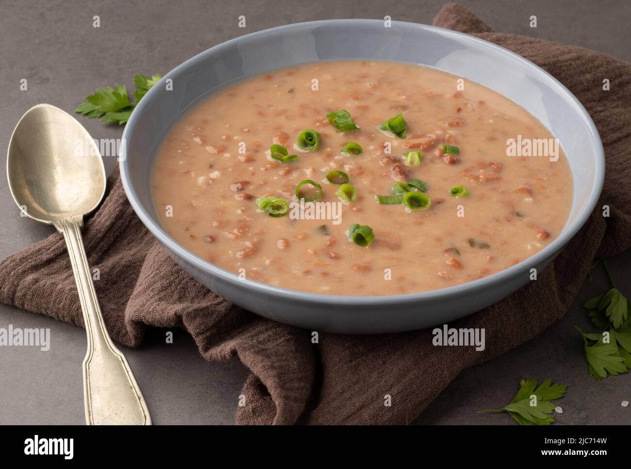 Brown bean soup in a bowl with seasoning over stone background Stock ...