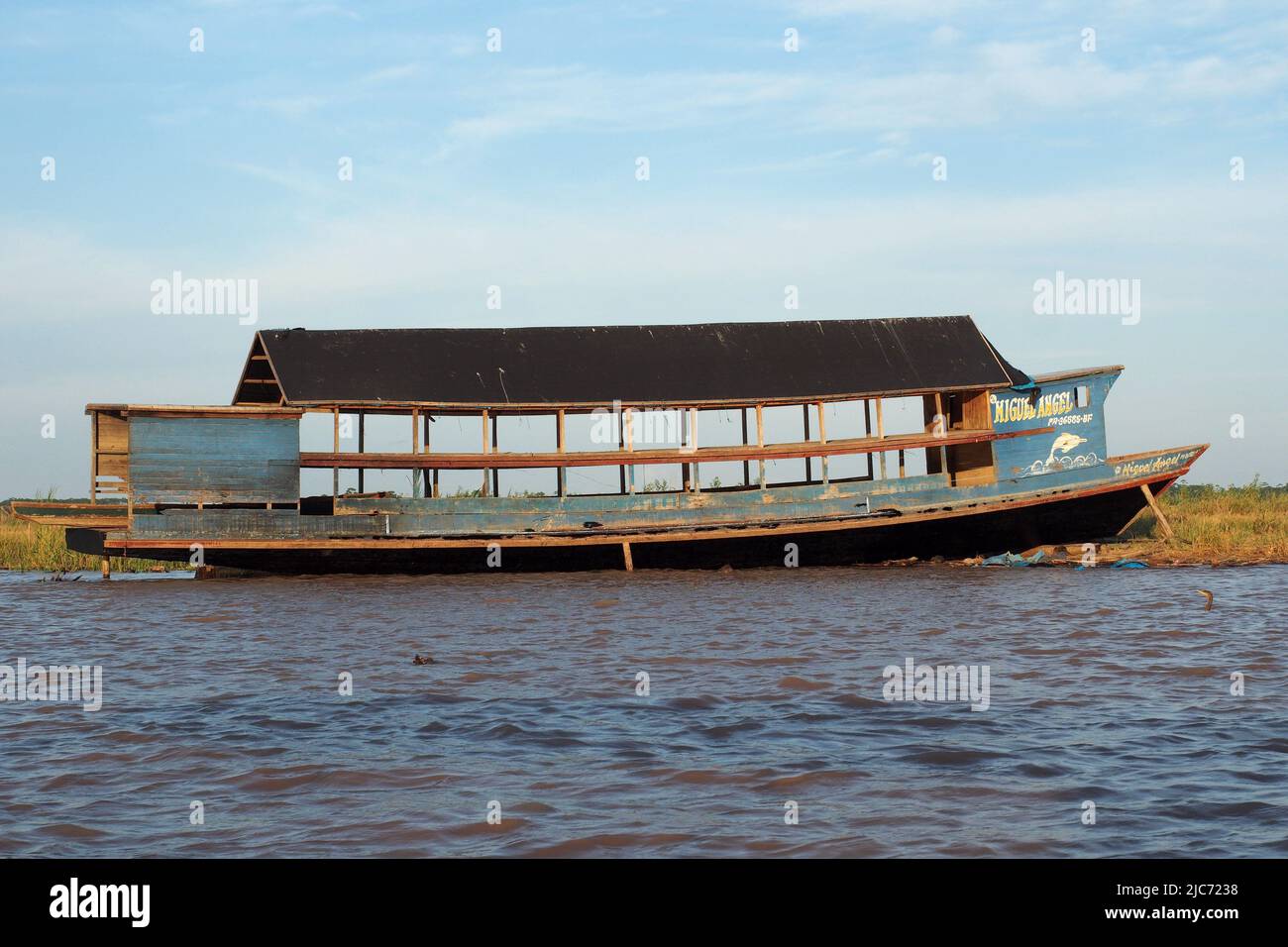 Side view of a typical wooden river boat stranded on a bank of the ...
